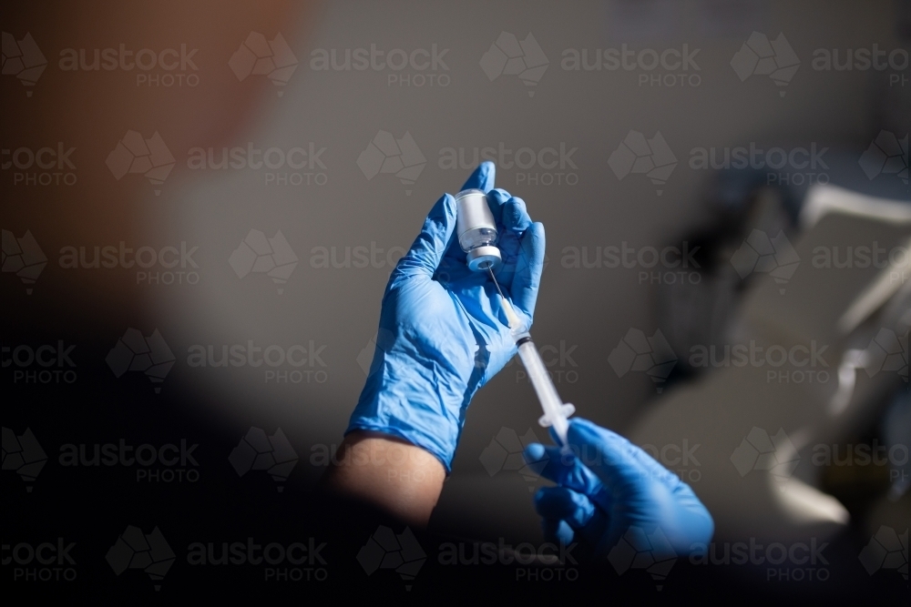 Image of Close up shot of a syringe being inserted to a medicine glass ...