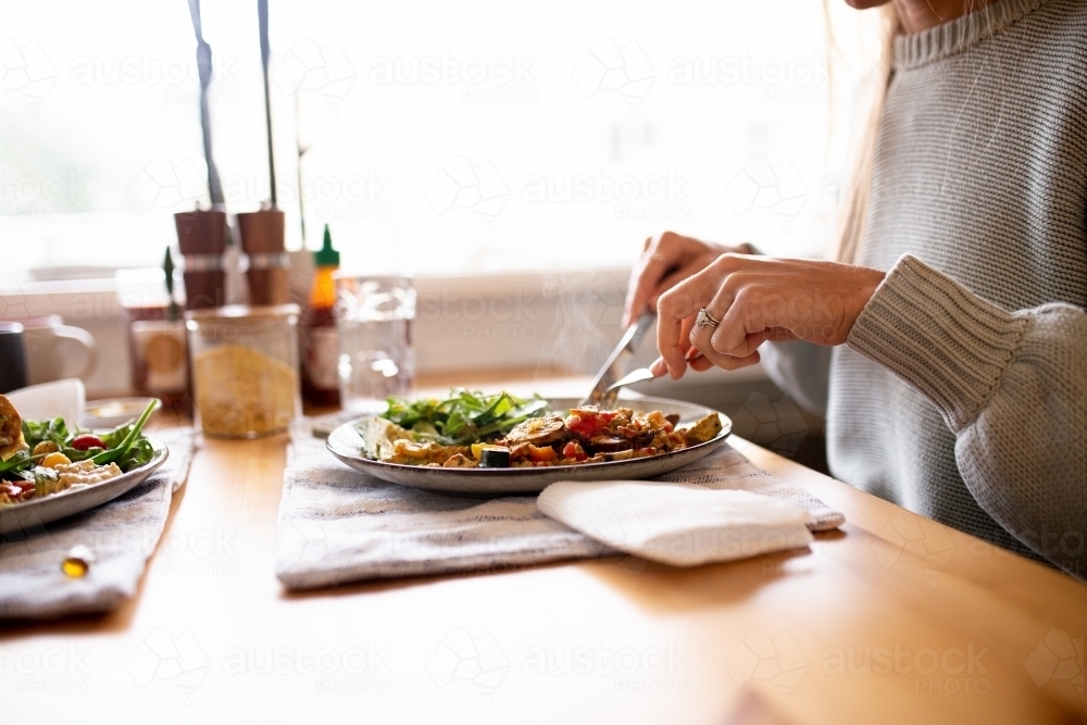 Image of Close up shot of a woman eating a healthy vegetable dish and ...