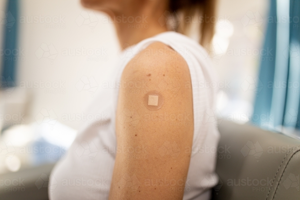 Image of Close up shot of a woman's arm with a circular band aid from a ...