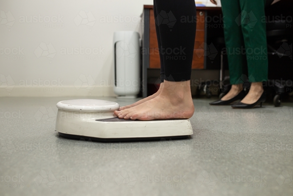Image of close up shot of a woman's bare feet on a weight scale ...
