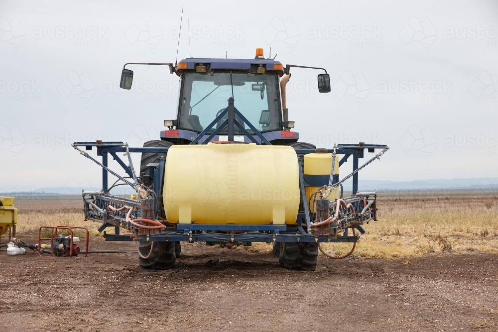 Image of close up shot of a yellow tractor in an empty field - Austockphoto