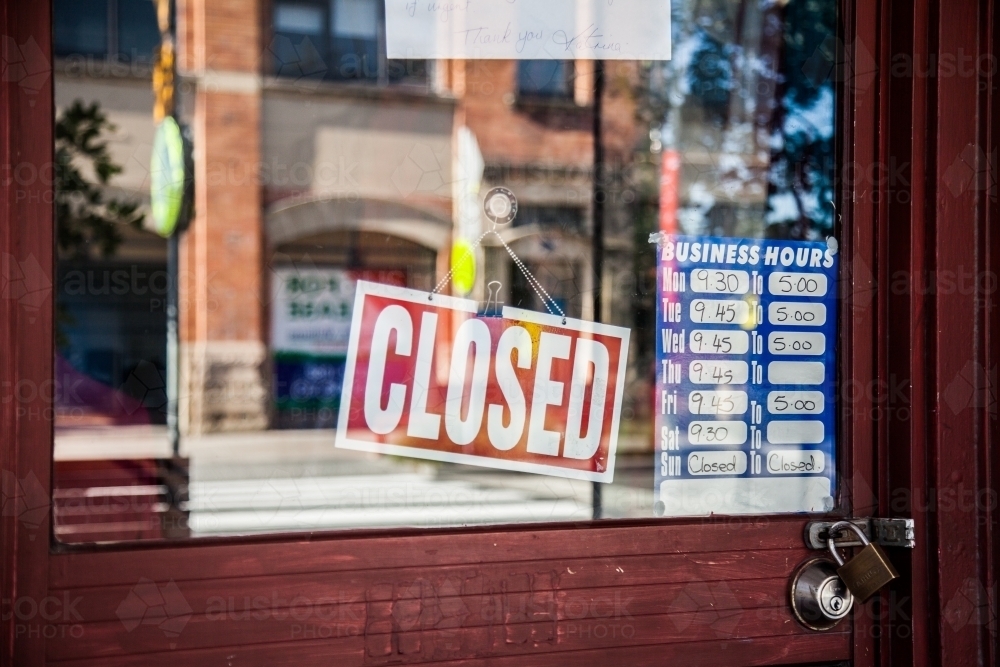 Image of Closed sign hanging in front window of shop - Austockphoto