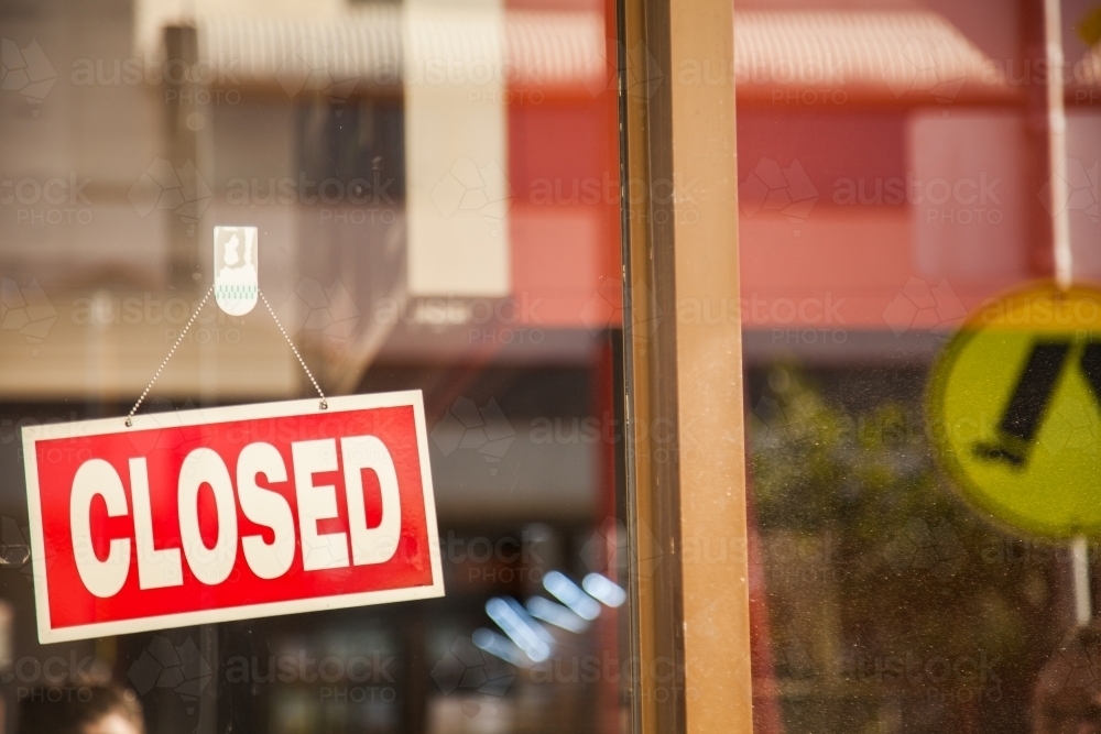 Image of Closed sign hanging in front window of shop - Austockphoto