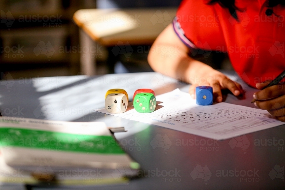Image of Closeup of dice and maths sheets - Austockphoto