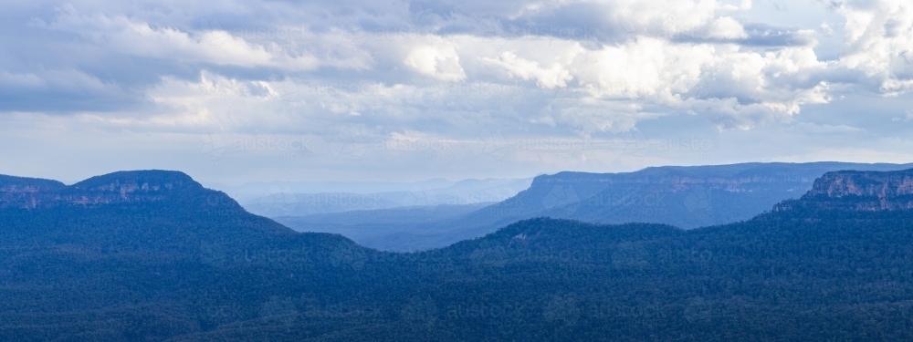 Image of clouded dusk sky over distant mountains fading into blue ...