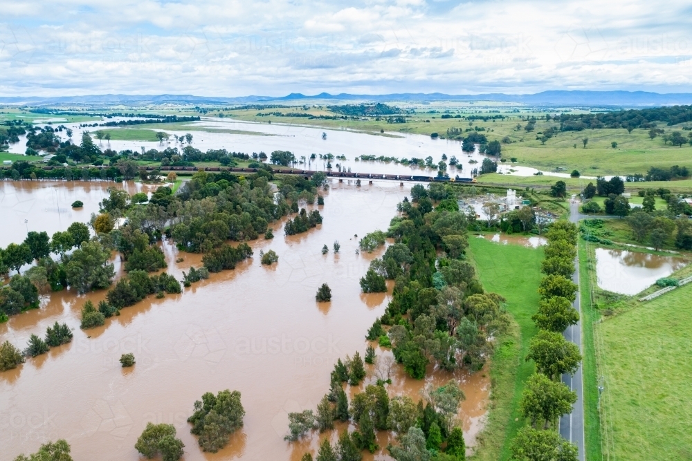 Image of Coal train crossing over bridge above flooding river in ...