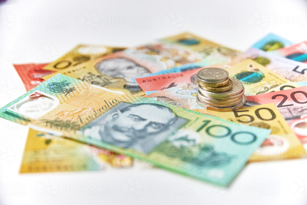 Image of Collection of Australian banknotes and coins scattered on a ...
