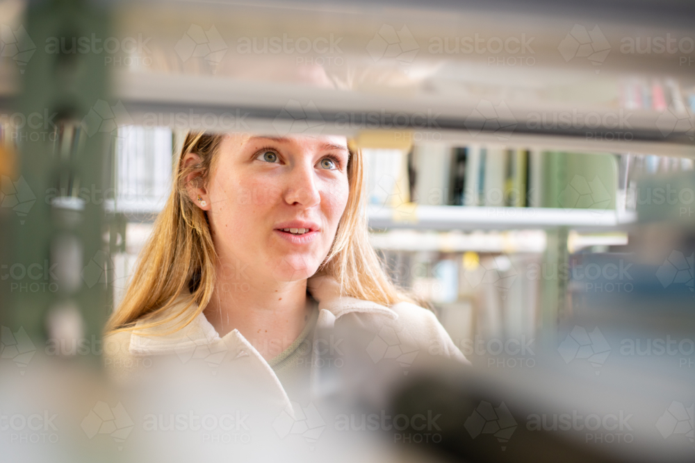 Image of college student's face seen through book stack - Austockphoto