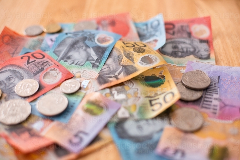 Image of colourful Australian notes and coins in a pile on a table ...