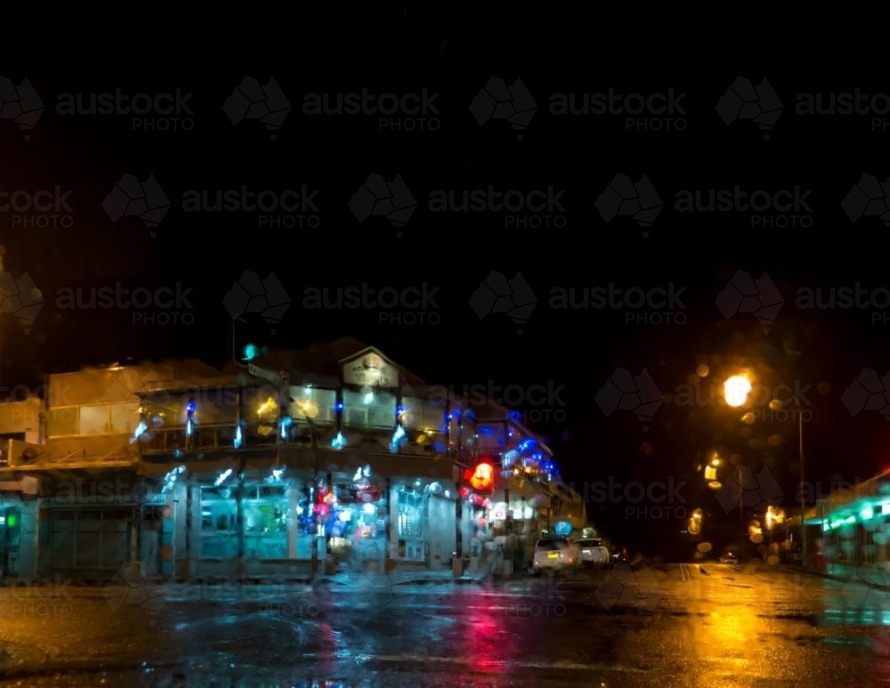 Image of Colourful distorted lights of a building on a wet street at ...