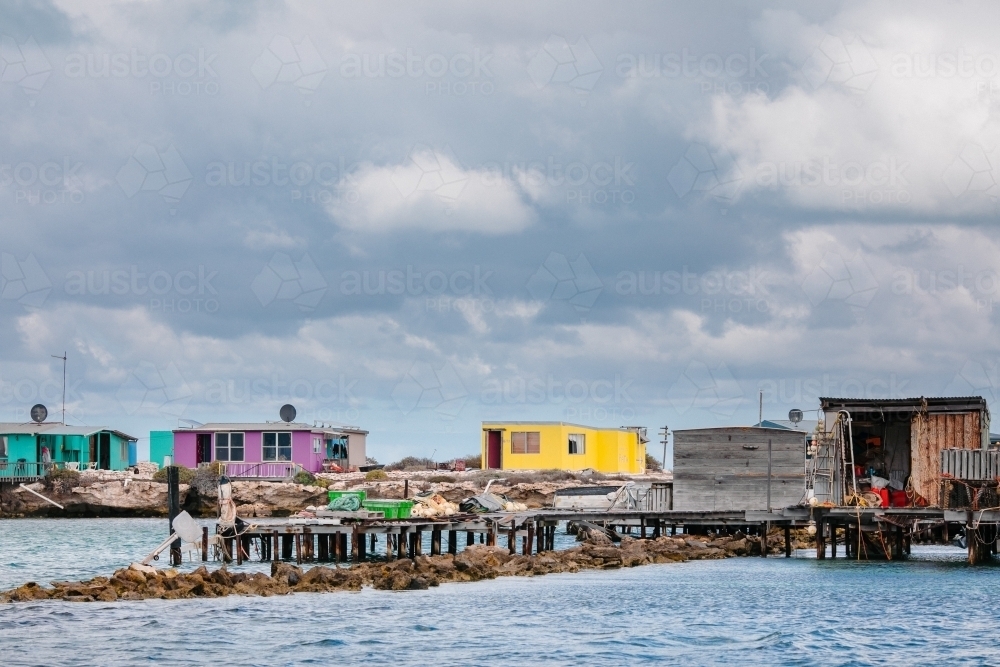 Image of Colourful fishing shacks and sheds with an old wooden jetty ...