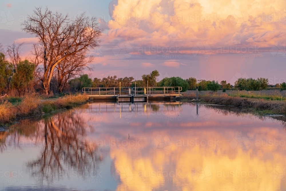 Image of Colourful storm clouds at twilight reflected in the water of ...