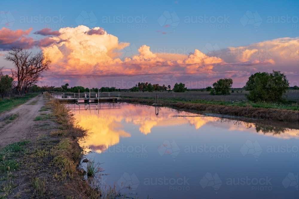 Image of Colourful storm clouds at twilight reflected in the water of ...