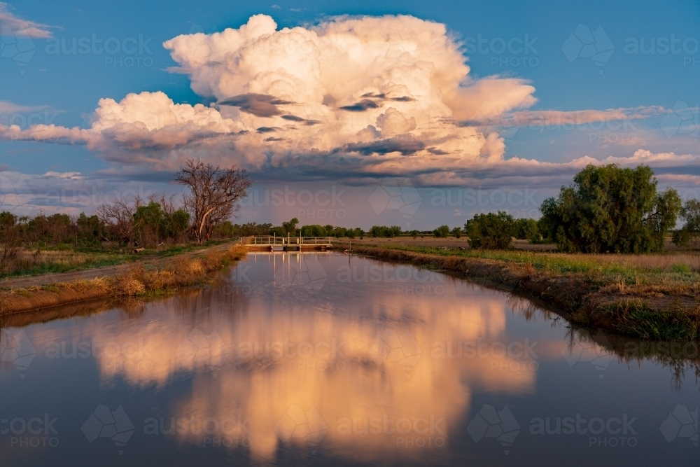 Image of Colourful storm clouds at twilight reflected in the water of ...