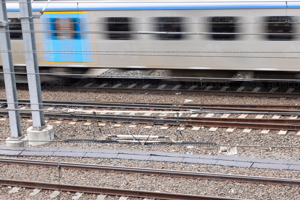 Image of commuter train going past railway tracks - Austockphoto