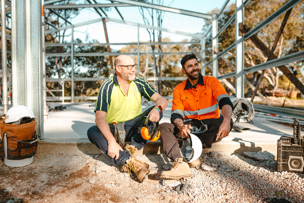 Image of Construction workers sitting on the cemented floor. - Austockphoto