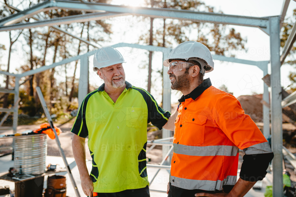 Image of Construction workers standing together talking at the ...
