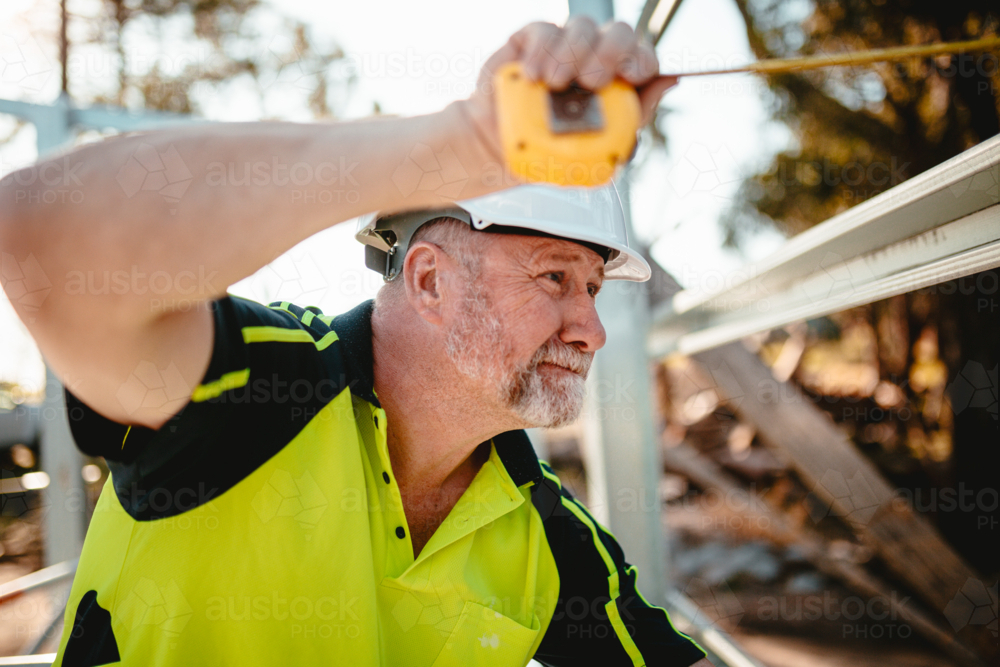 Image of Contractor holding a measuring tool to get measurements on ...