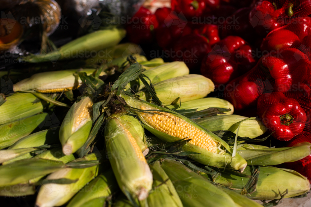 Image of corn on the cob and capsicum for sale in piles - Austockphoto
