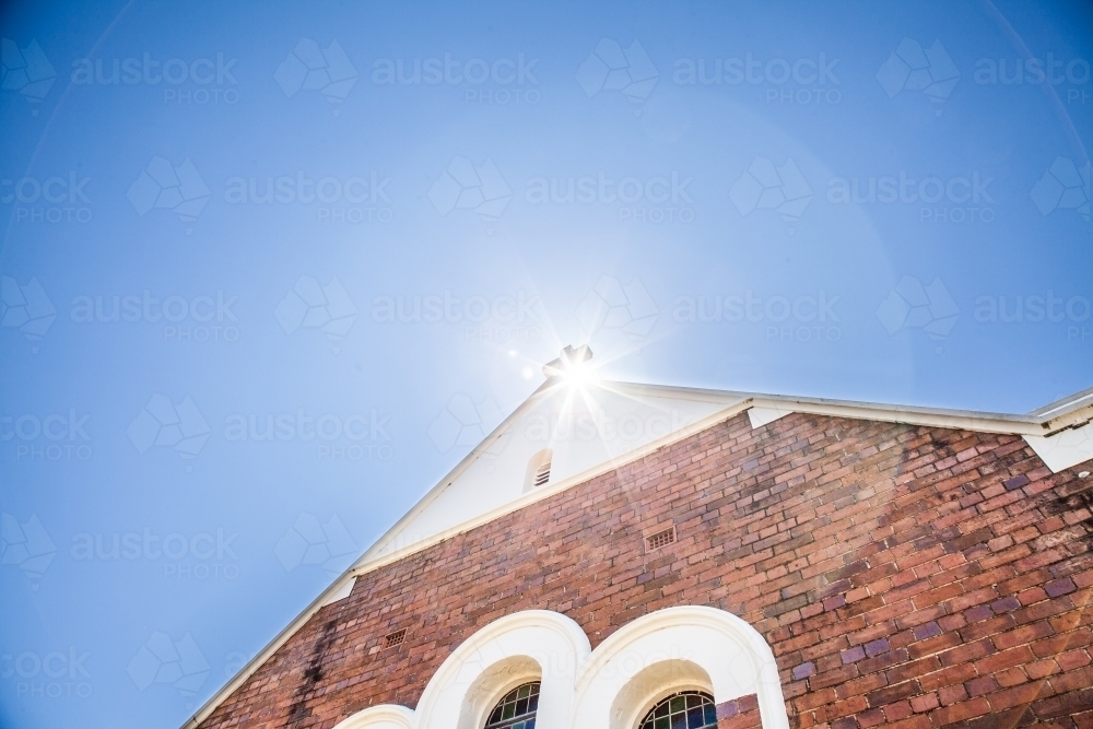 Image of Country Church with sunlight shining over the roof - Austockphoto