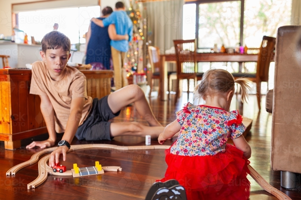 Image of Cousins playing with wooden train set gift together at ...