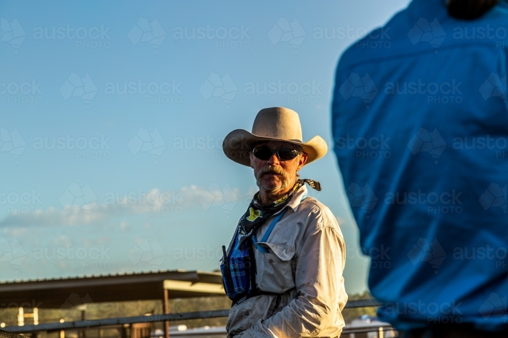 Image of Cowboy facing camera, talking to a cowgirl. - Austockphoto