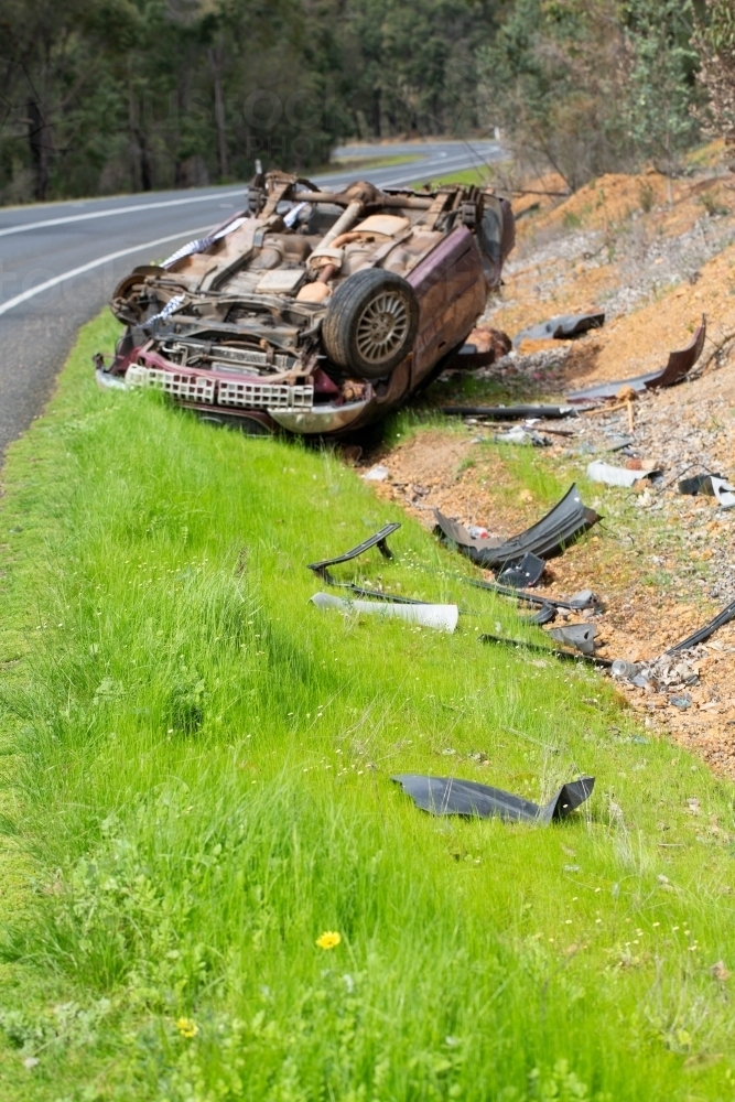 Image of Crashed vehicle upside down on side of highway - Austockphoto