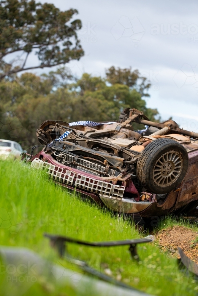 Image of Crashed vehicle upside down on side of highway - Austockphoto
