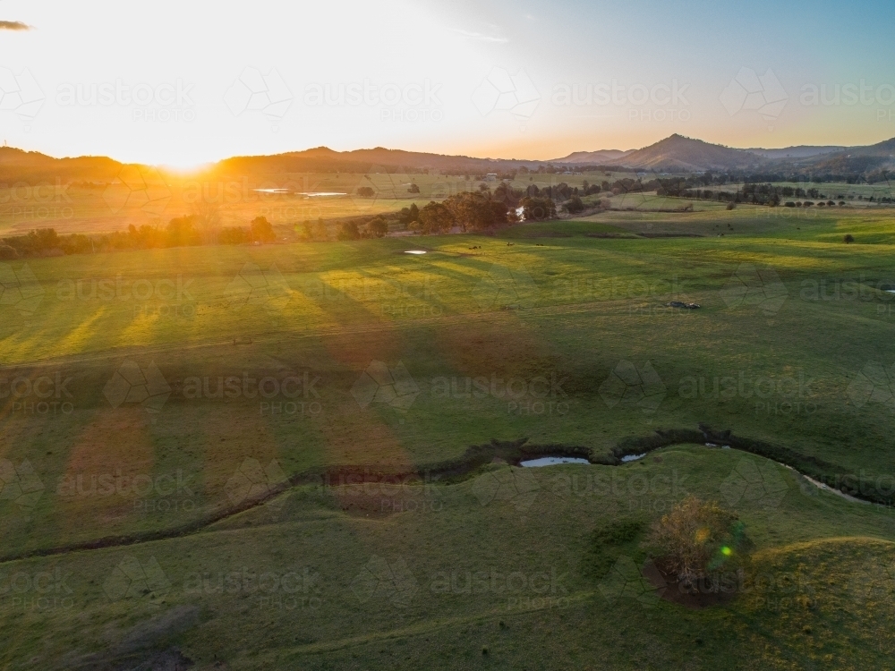Image of Creek winding through green Australian farm landscape ...