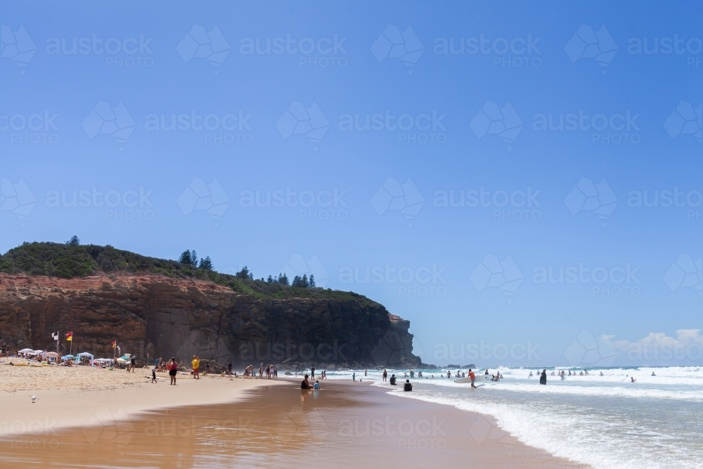 Image of Crowded beach with people swimming between SLS flags ...