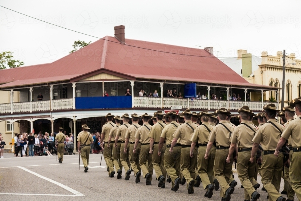 Image of Crowds come out to watch army soldiers marching down main ...