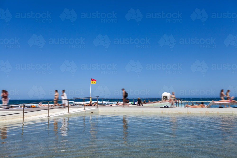 Image of crowds sunbathing with motion blurred people walking past ...