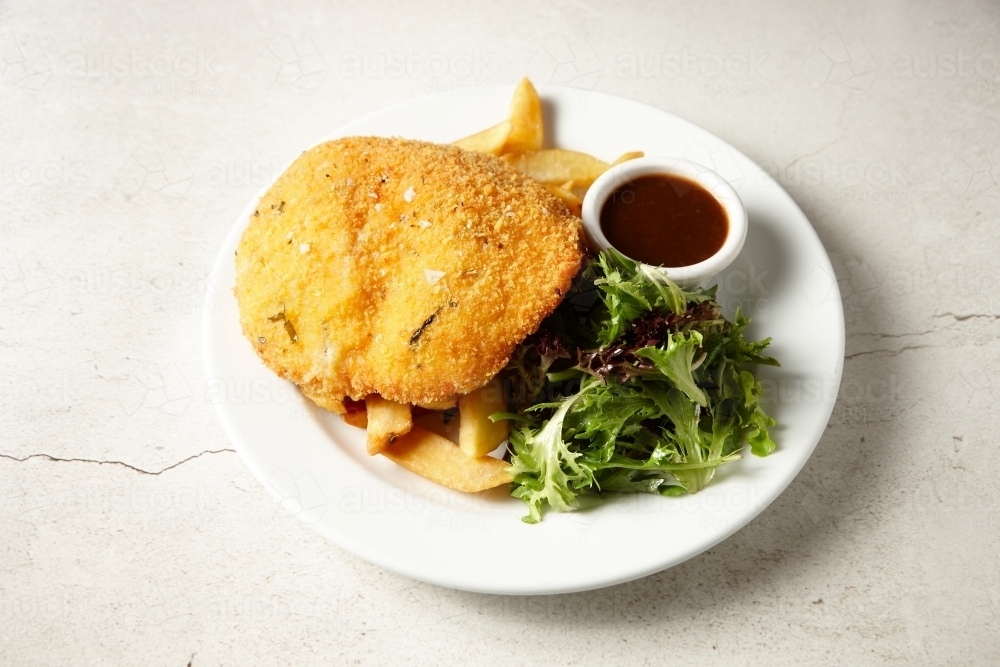 Image of Crumbed fish with chips and salad on plate - Austockphoto