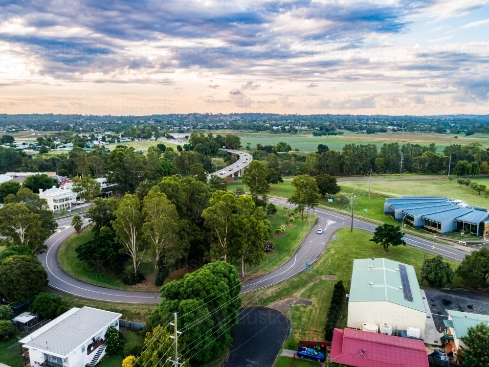 Image of Curved road off highway at dusk with park and trees - Austockphoto