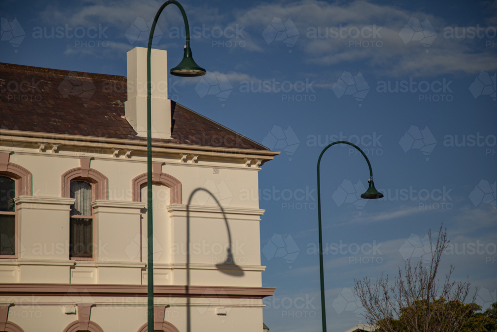 Image of Curved street light casting shadow on historic building in ...