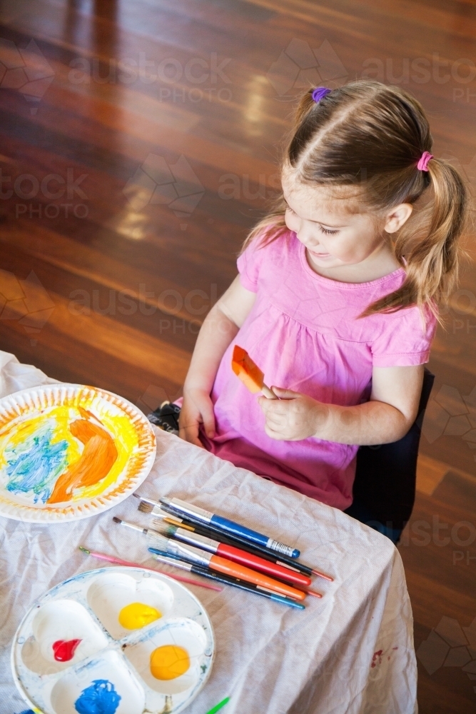Image of Cute child making a painted craft for schoolwork - Austockphoto