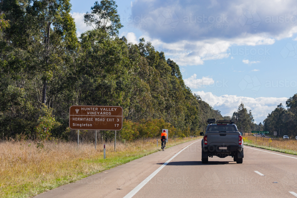 Image of Cyclist on roadside with signage to Hunter valley Vineyards ...