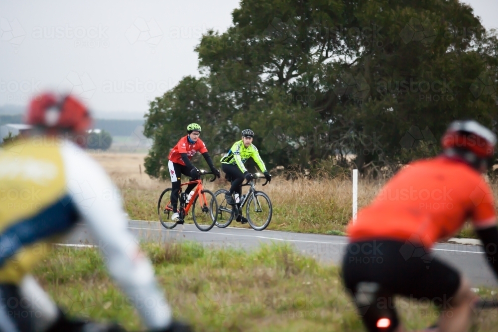 Image of Cyclists waiting at intersection for another group to pass ...