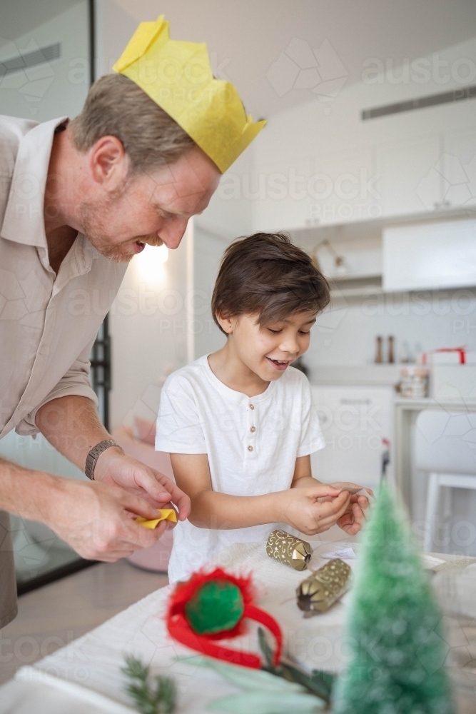 Image of Dad and son looking inside Christmas bon-bon together ...