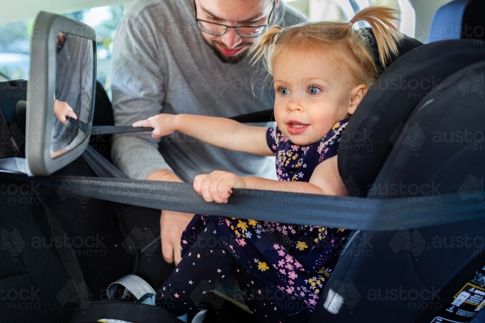 Image of Dad buckling toddler into extended rear facing car seat ...