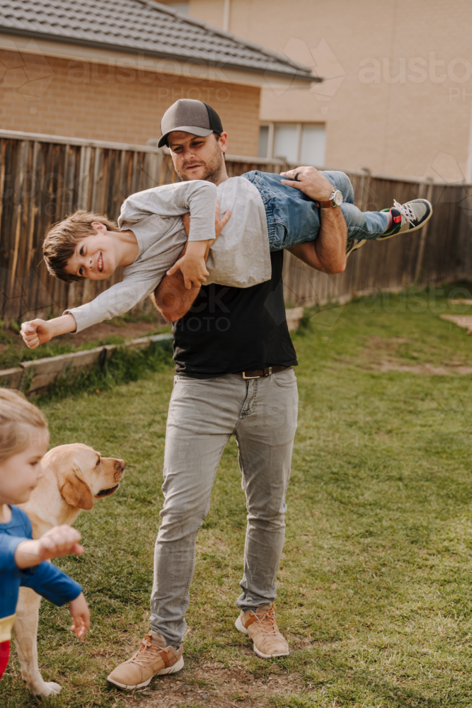 Image of Dad holding his son upside down pretending to fly playing ...