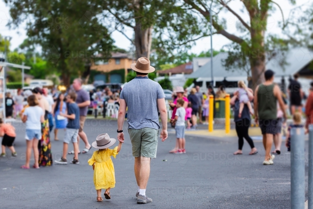 Image of Dad walking through crowds at event with toddler - Austockphoto
