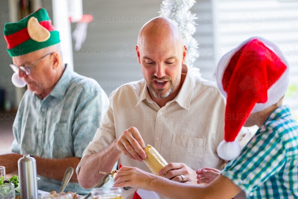 Image of Dad with popped bon bon at Christmas lunch - Austockphoto