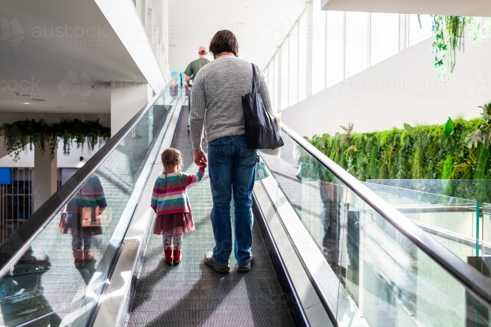Image of Dad with toddler daughter holding hands as they go home after ...
