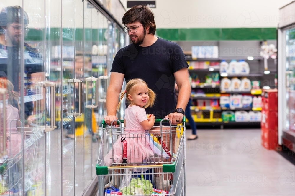Image of Dad with toddler in shopping trolley buying groceries at shops ...