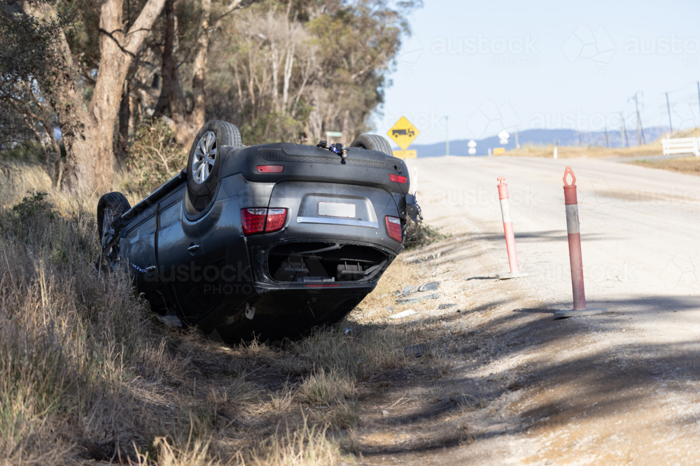 Image of Damaged and overturned car on the roadside - Austockphoto
