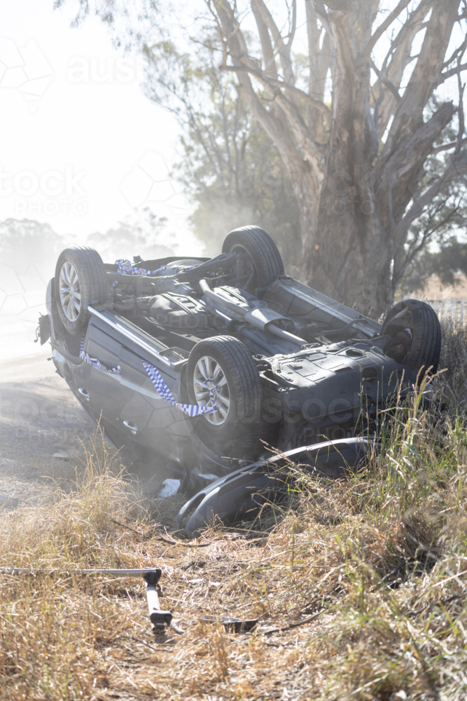 Image of Damaged and overturned car on the roadside - Austockphoto