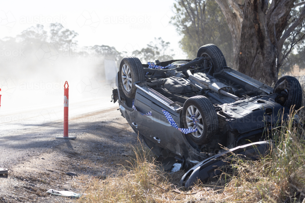 Image of Damaged and overturned car on the roadside - Austockphoto