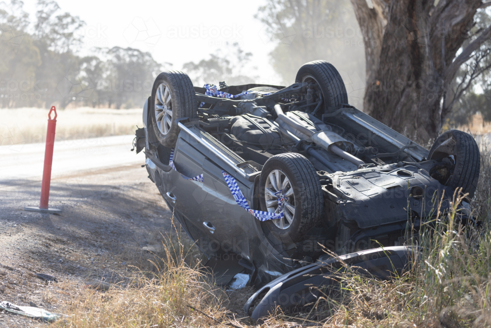 Image of Damaged and overturned car on the roadside - Austockphoto