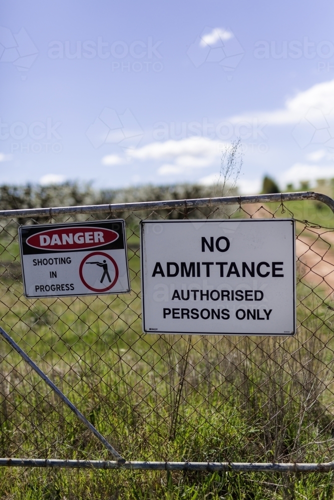Image of danger and keep out signs on an orchard gate - Austockphoto